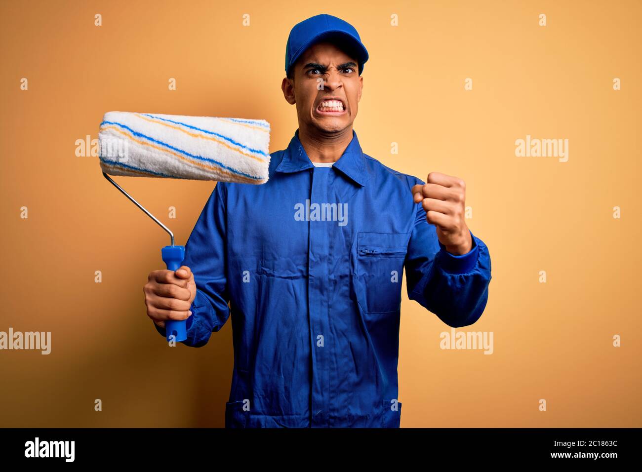 Young handsome african american painter man wearing uniform using ...