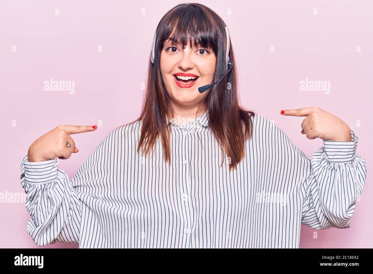 Young plus size woman wearing call center agent headset looking confident with smile on face ...