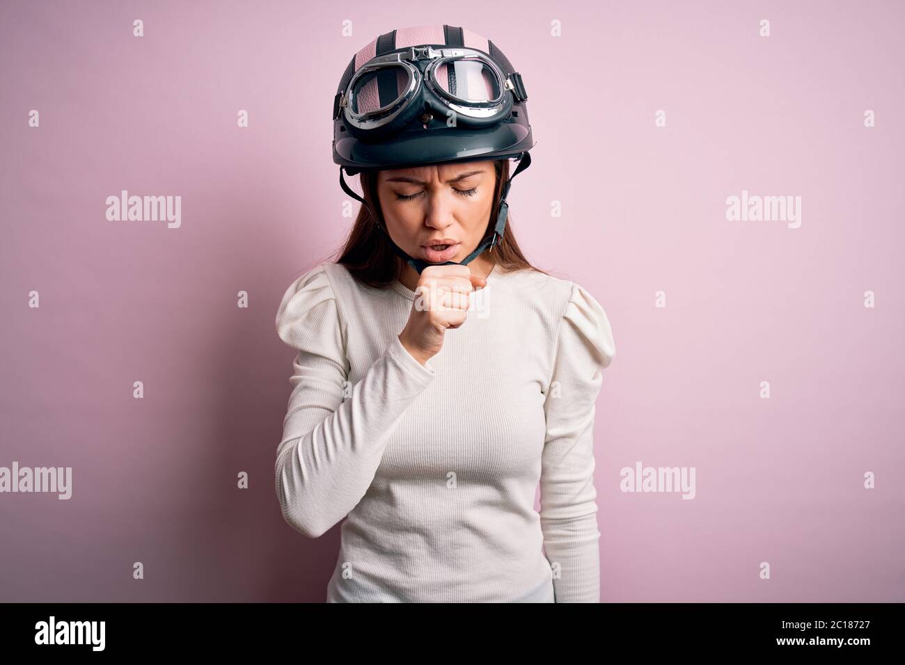 Young beautiful motorcyclist woman with blue eyes wearing moto helmet ...