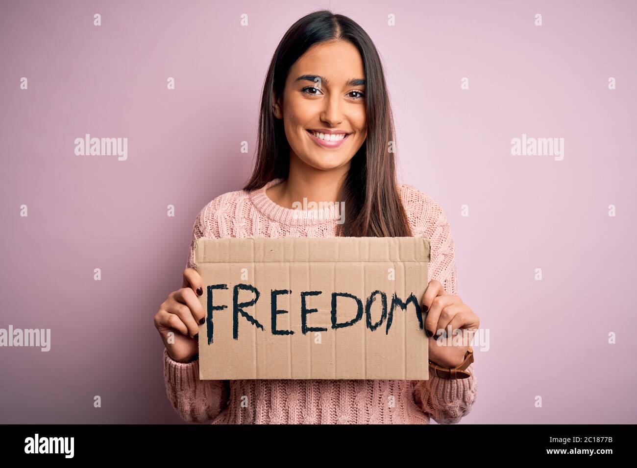 Young beautiful brunette activist woman protesting for freedom holding ...