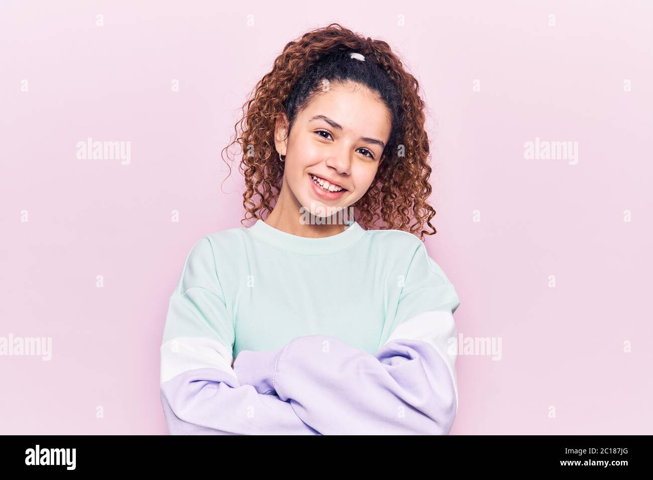 Beautiful kid girl with curly hair wearing casual sporty clothes happy ...