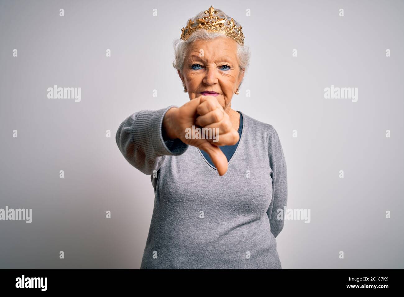 Senior beautiful grey-haired woman wearing golden queen crown over ...