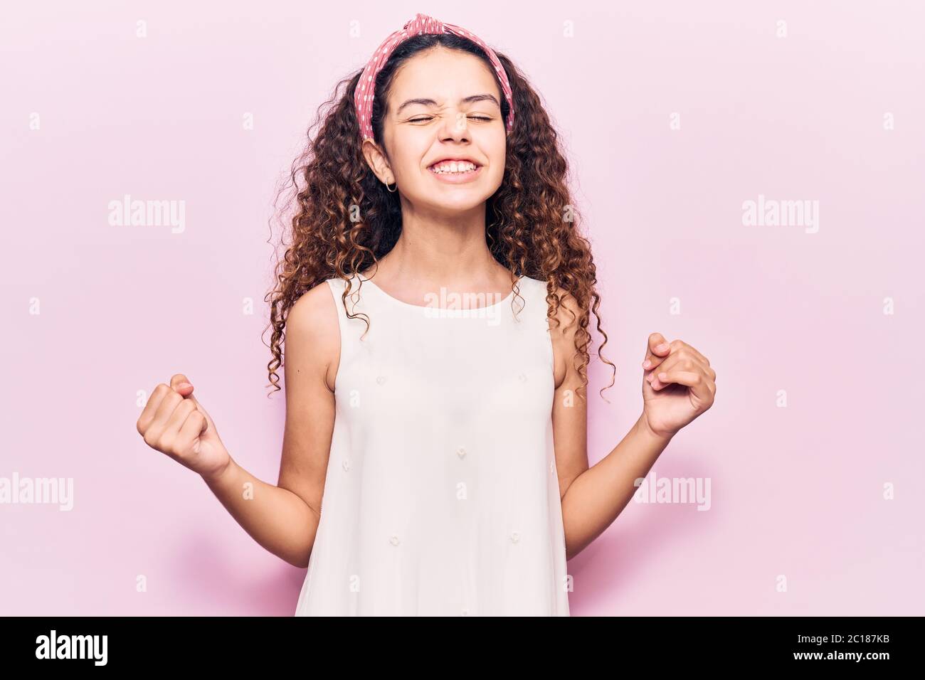 Beautiful kid girl with curly hair wearing casual clothes very happy ...