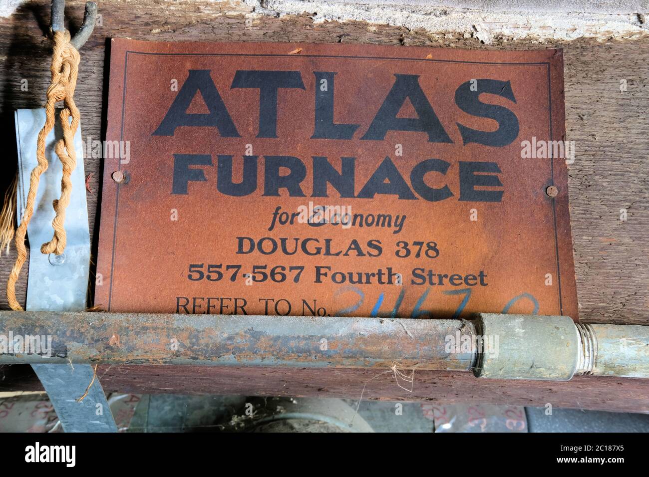 Atlas Furnace for Economy paper sign nailed to a wood beam in a ...