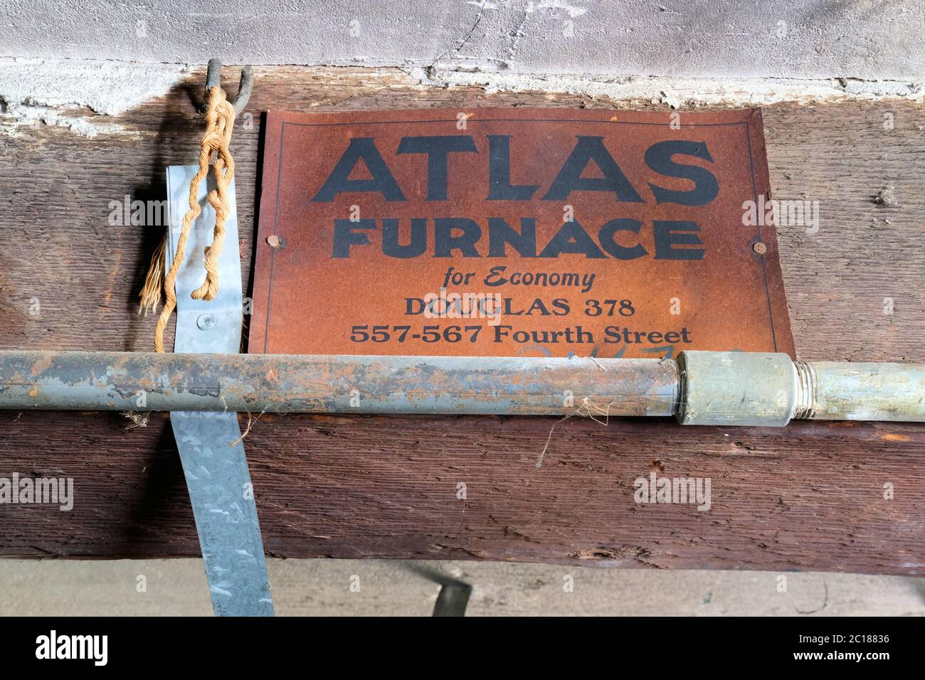 Atlas Furnace for Economy paper sign nailed to a wood beam in a ...