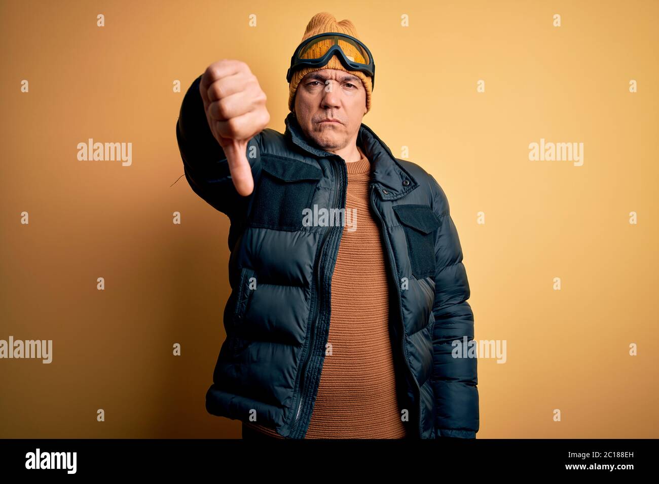 Middle age handsome grey-haired skier man on vacation wearing ski ...