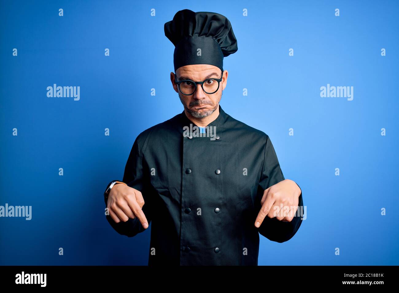Young handsome chef man wearing cooker uniform and hat over isolated ...