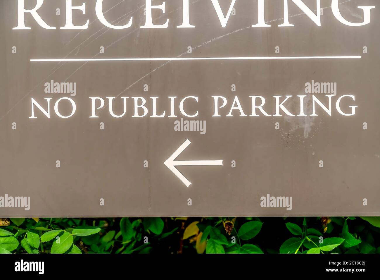 No Public parking sign with arrow at the Receiving area outside a ...