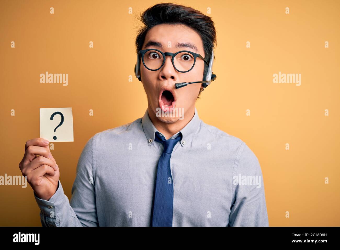 Young handsome chinese call center agent man holding paper with ...