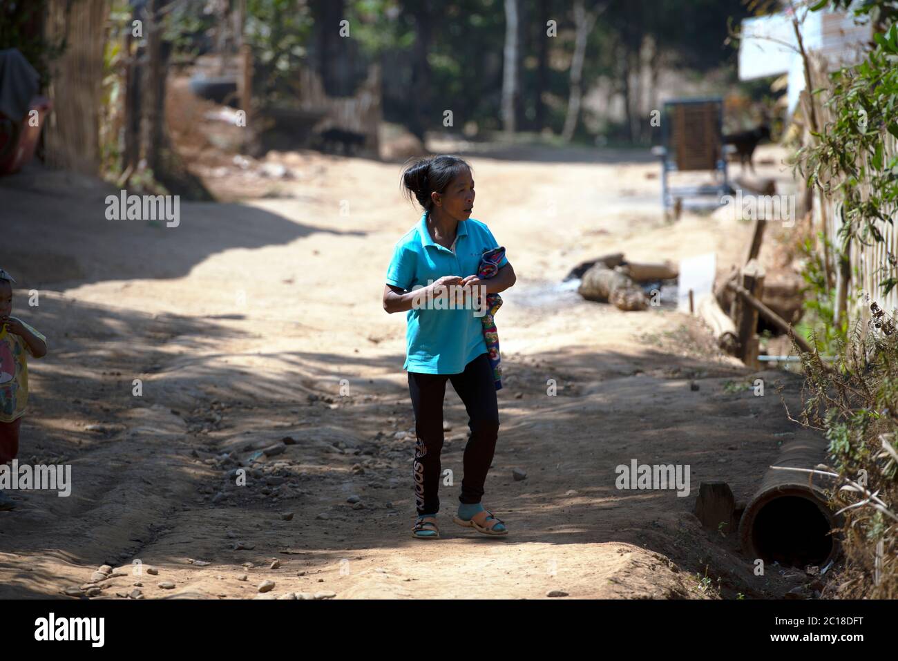An indigenous, ethnic Shan woman walking in Kong Mung Mong village ...