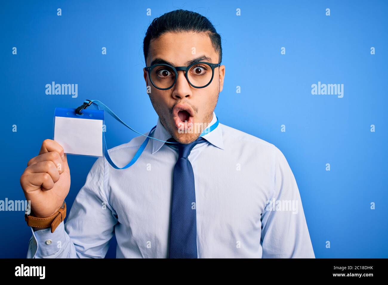 Young brazilian call center agent man holding id identification card ...