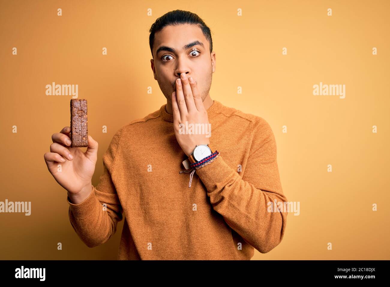 Young brazilian man eating healthy energy bar with protein over ...