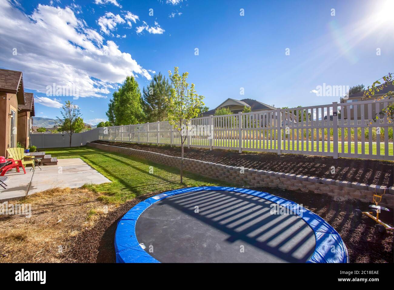 Backyard of home with trampoline patio and raised planting bed beside ...