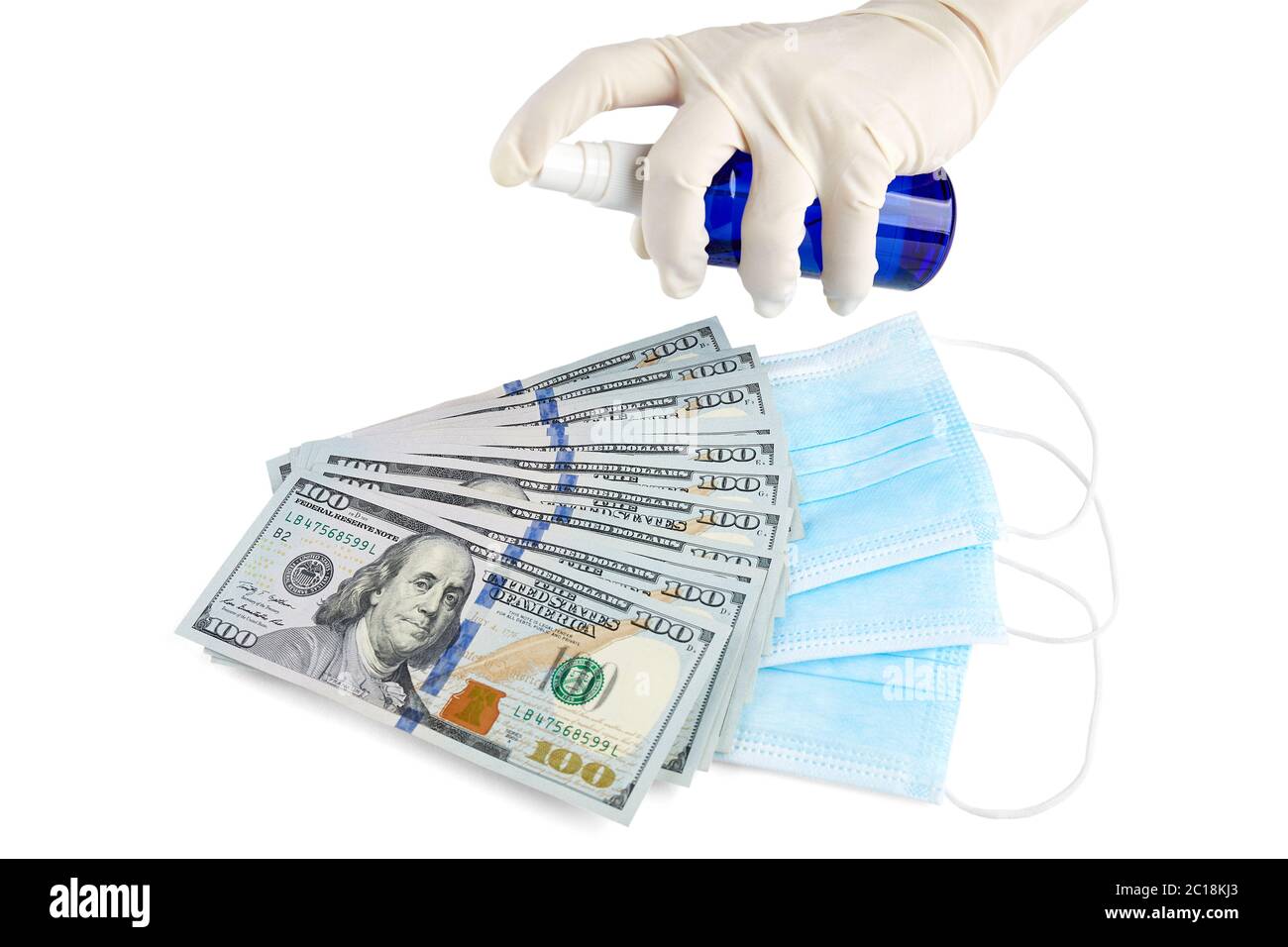 Antiseptic spray in hand, blue medical face masks and stack of 100 USD ...