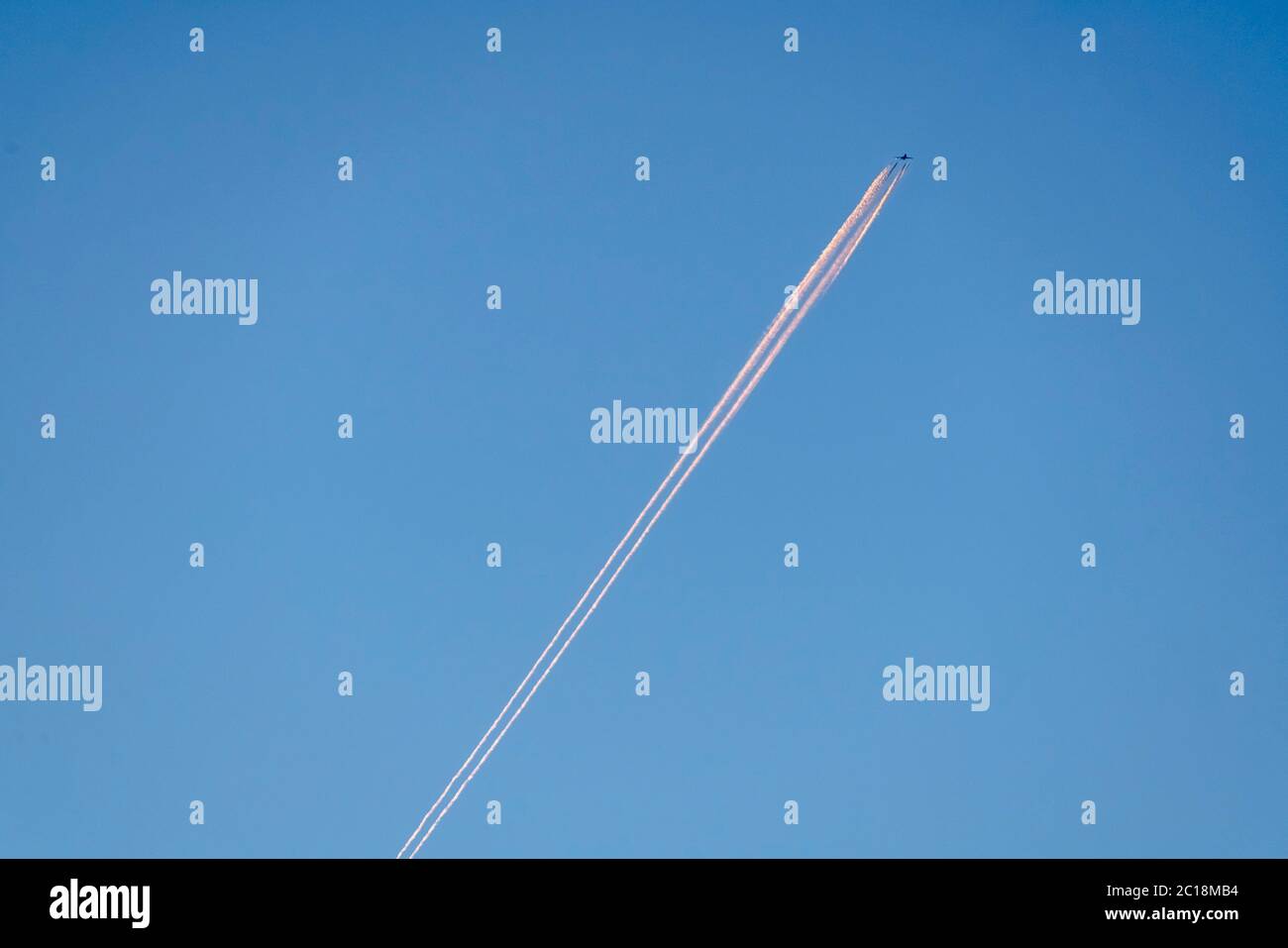 Contrail behind a climbing jetliner day light Stock Photo - Alamy