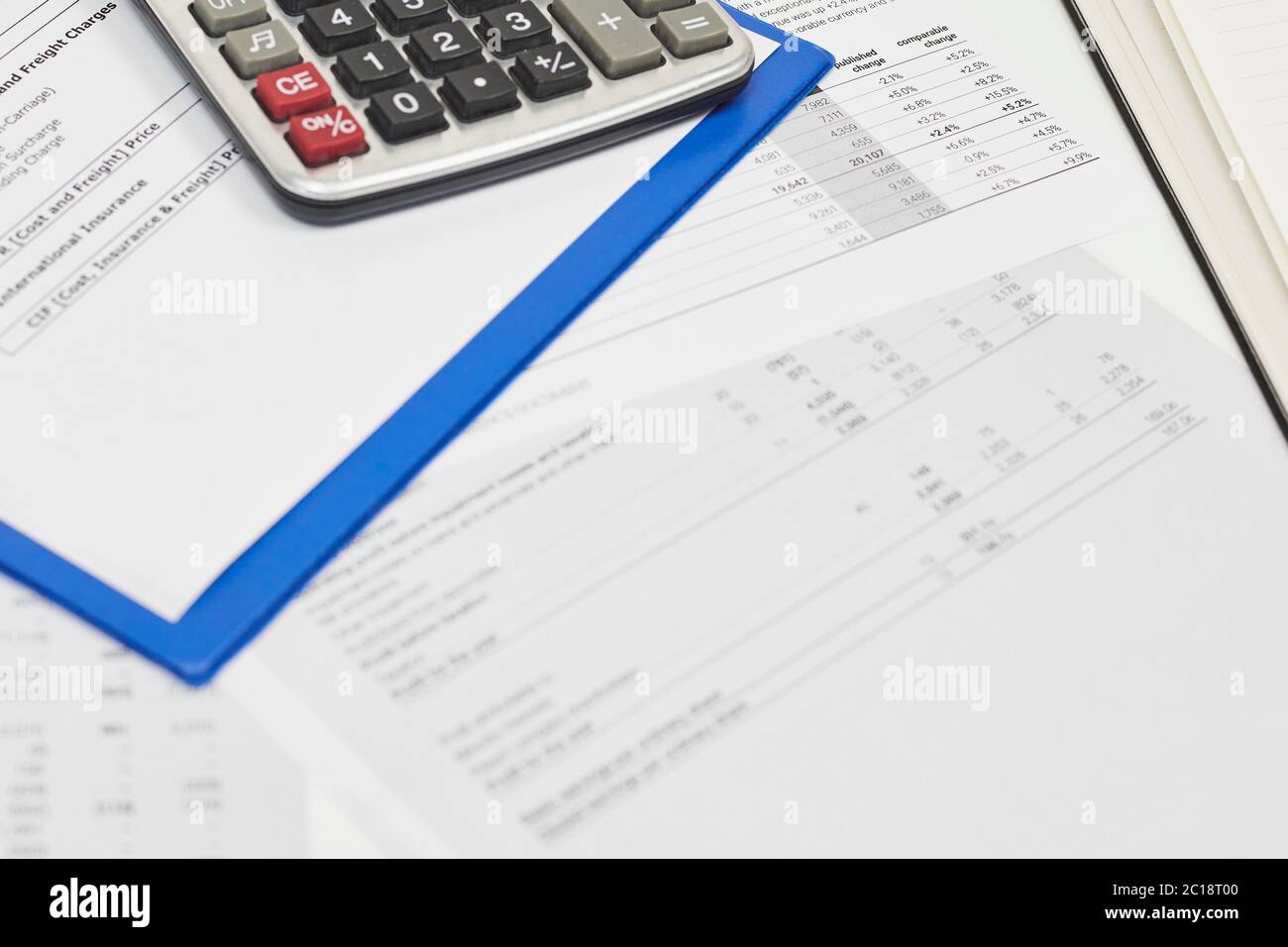 Calculating export import cost. Stack of statistic data, calculator and ...