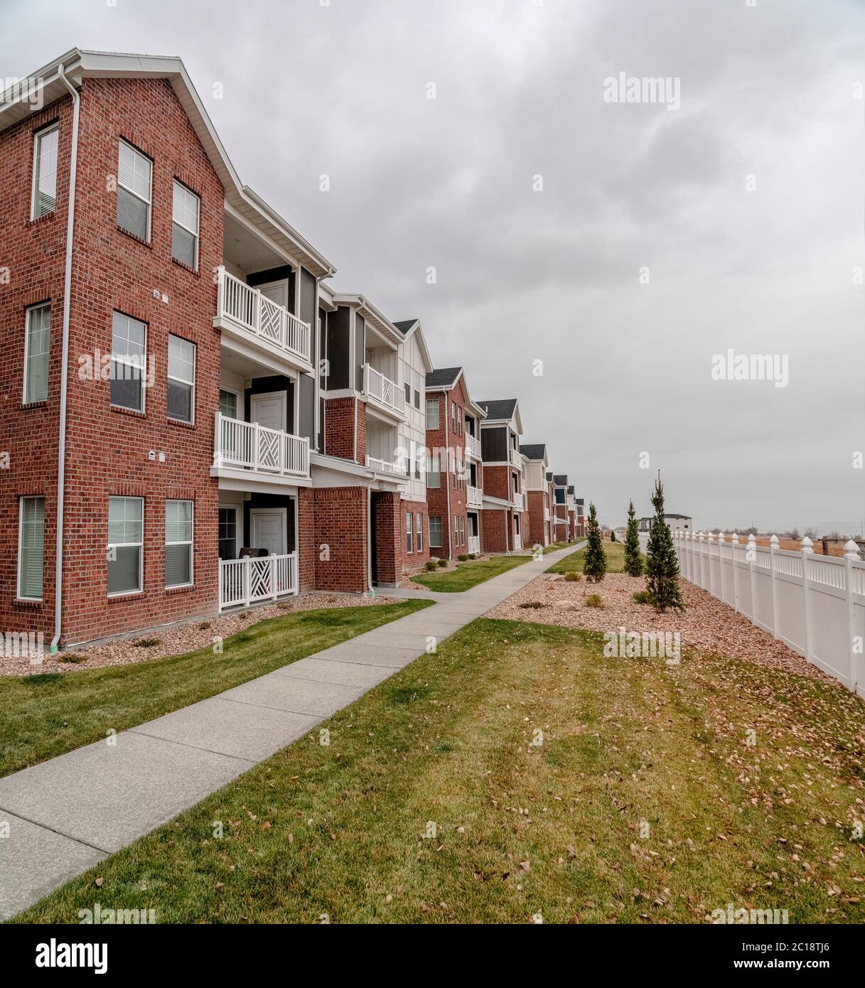 Modern brick apartment complex with balconies day light Stock Photo - Alamy