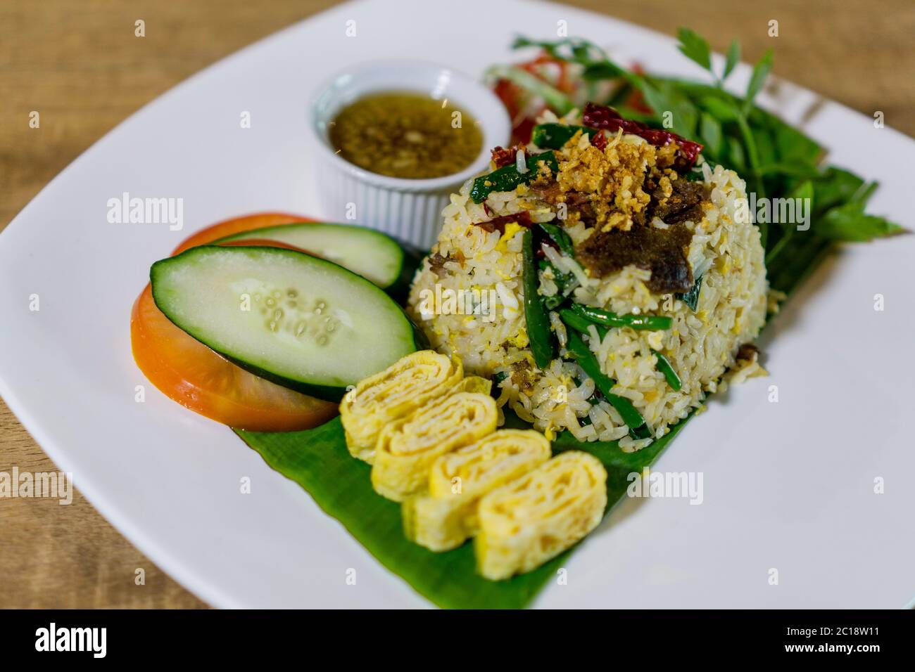 Spicy fried rice with beef and water spinach with sliced egg roll and ...