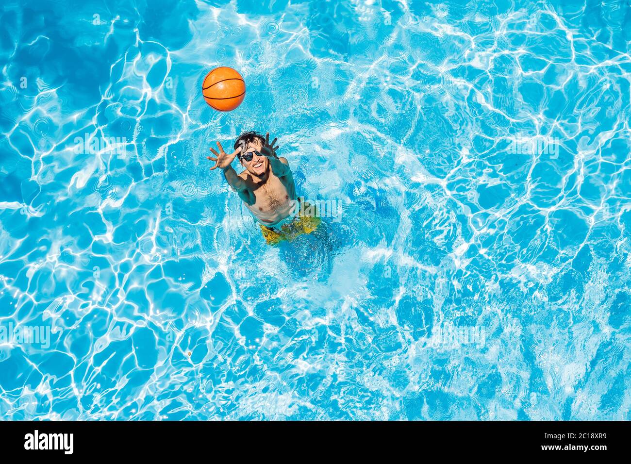 Young woman with a beach ball in the pool hi-res stock photography and ...