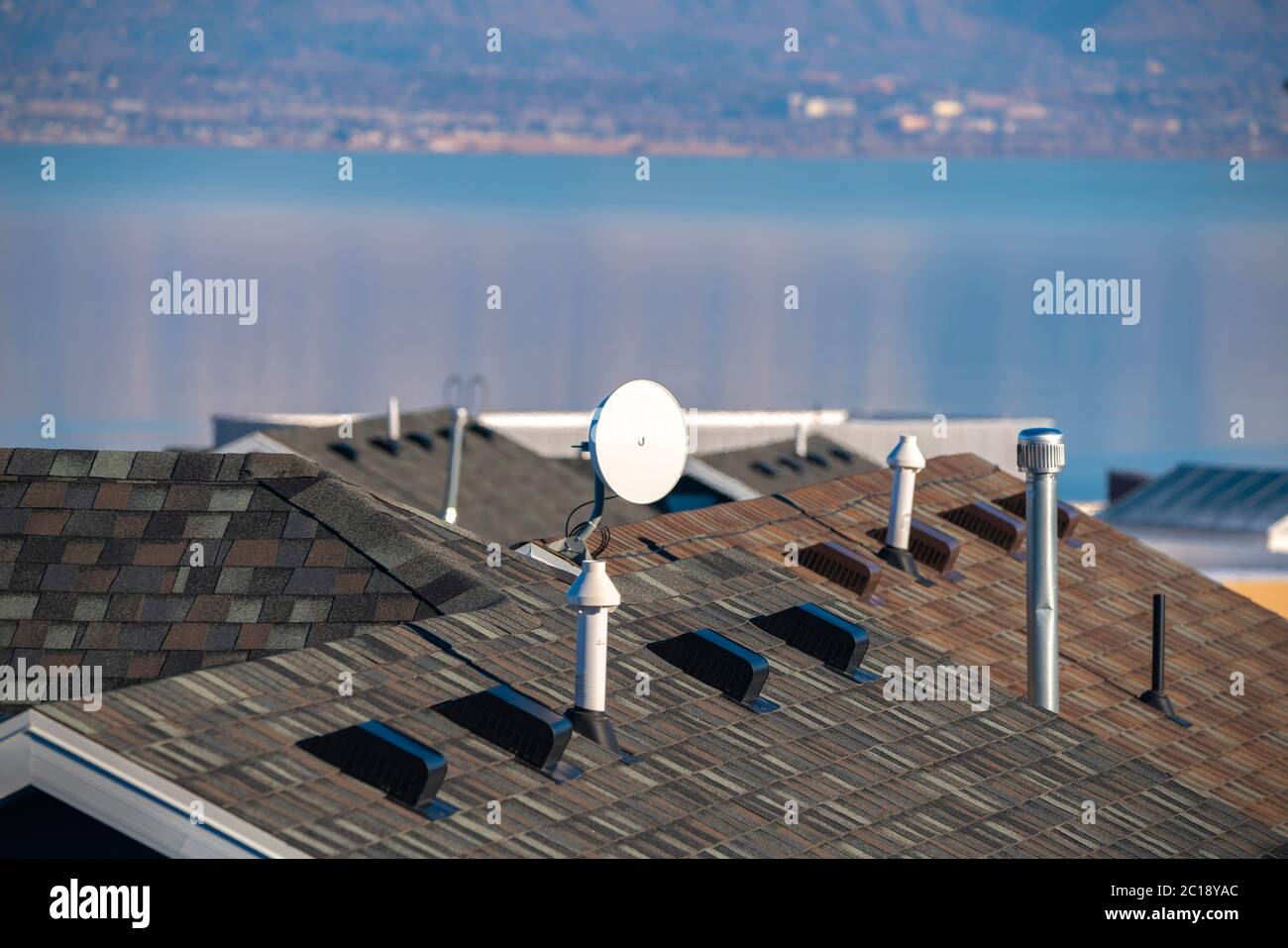 Television satellite dish mounted on a roof Stock Photo - Alamy