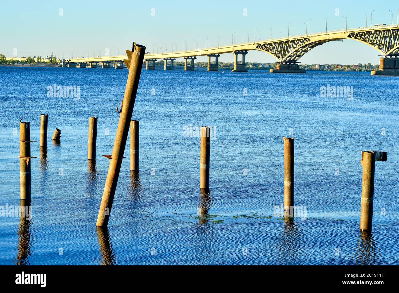 Wooden posts for the berth of boats and boats on the reservoir in the ...