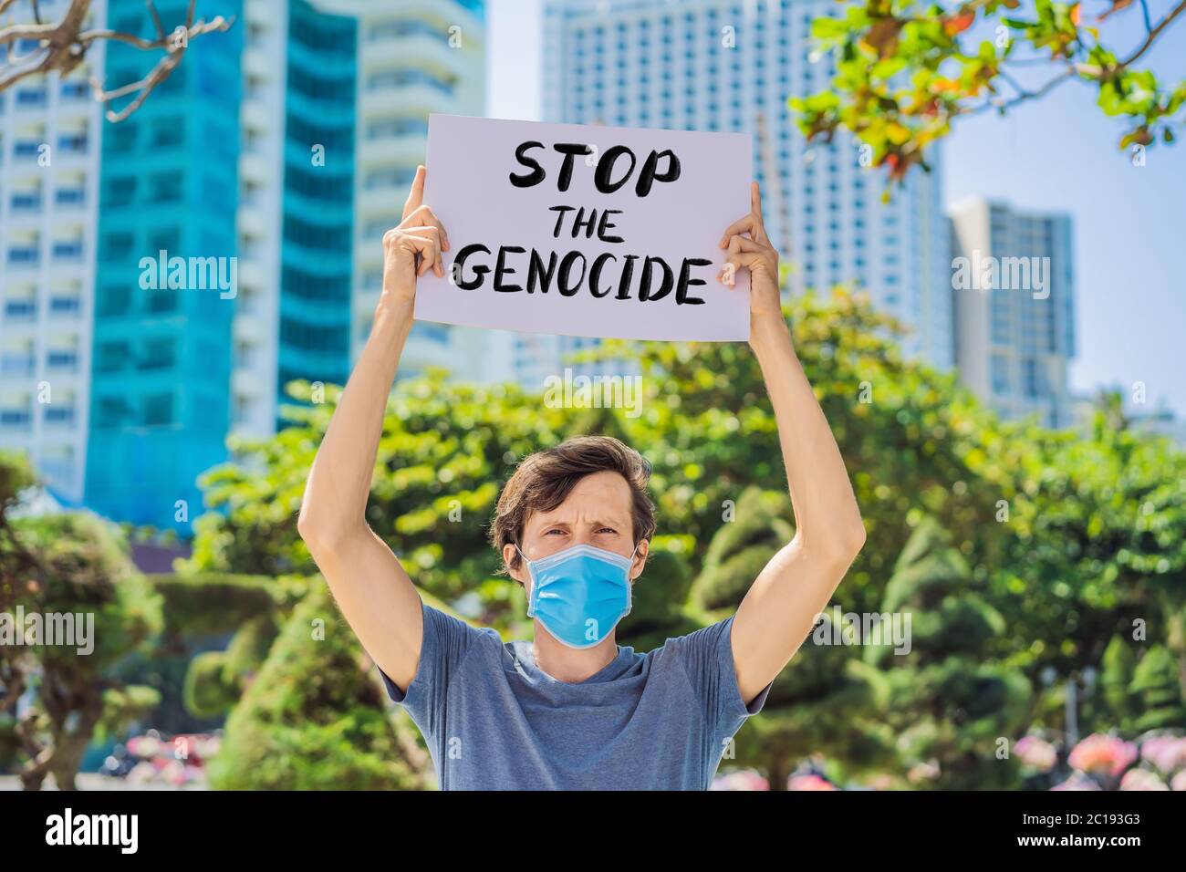 man holds a poster with an inscription - stop the genocide Stock Photo ...