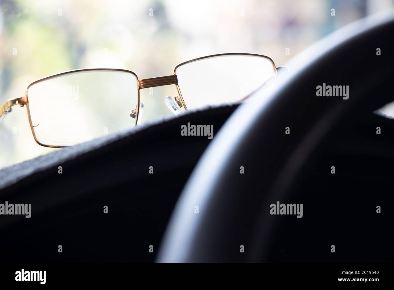 Glasses lie on car dashboard. Steering wheel with eyeglasses Stock ...
