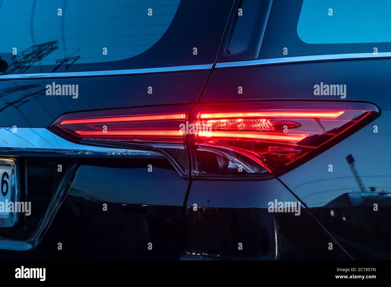 A tail-light of car at night city. A red light at the rear of a modern ...
