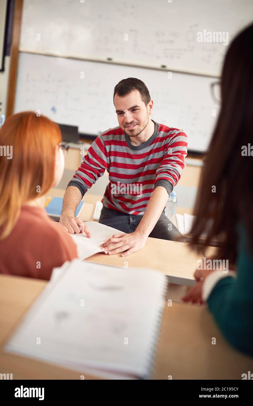 Male colleague helping female classmate in amphitheater Stock Photo - Alamy