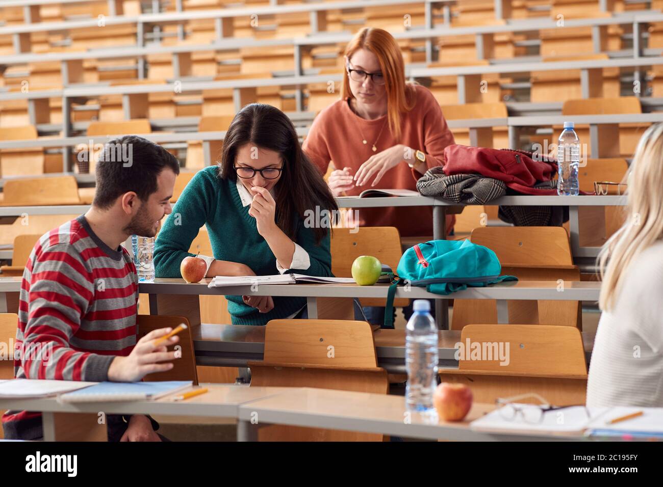Young freshman students talking and smiling in amphitheater Stock Photo ...
