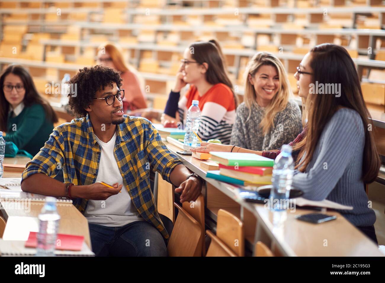 Young freshman students talking and smiling in amphitheater Stock Photo ...