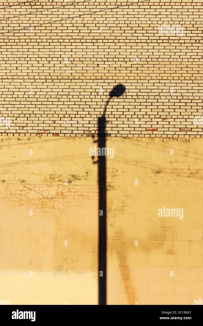 a lonely street lamp and its shadow on the wall of the house, painted ...