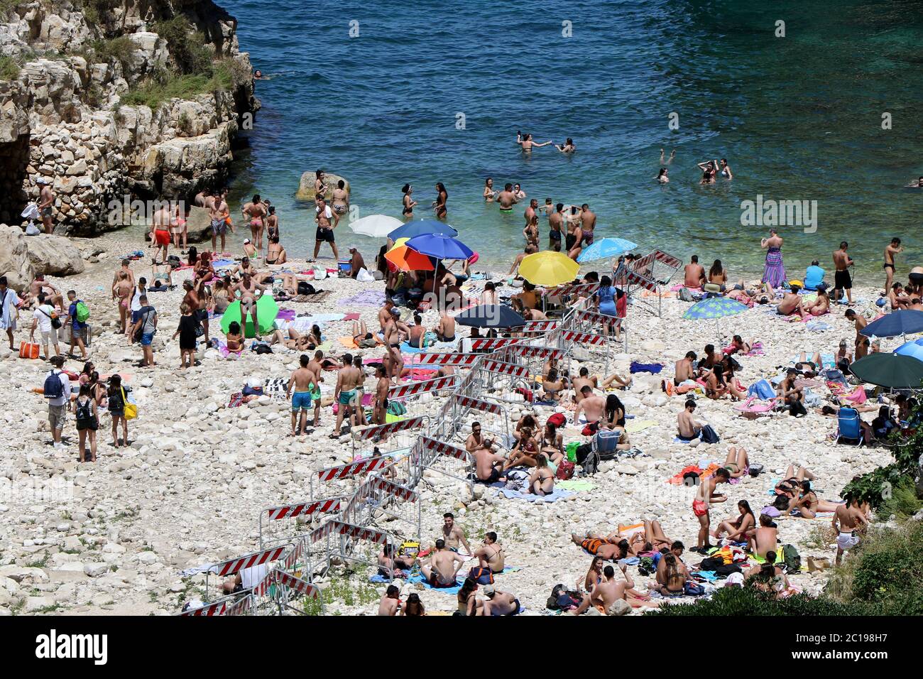 Bathers and tourists in the famous Lama Monachile beach in Polignano a ...
