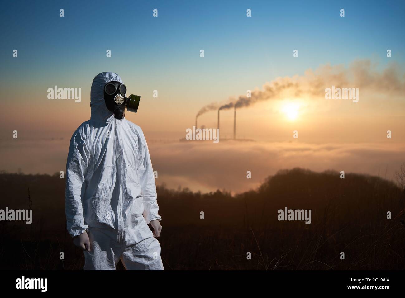 Portrait of a scientist wearing white protective uniform and gas mask ...