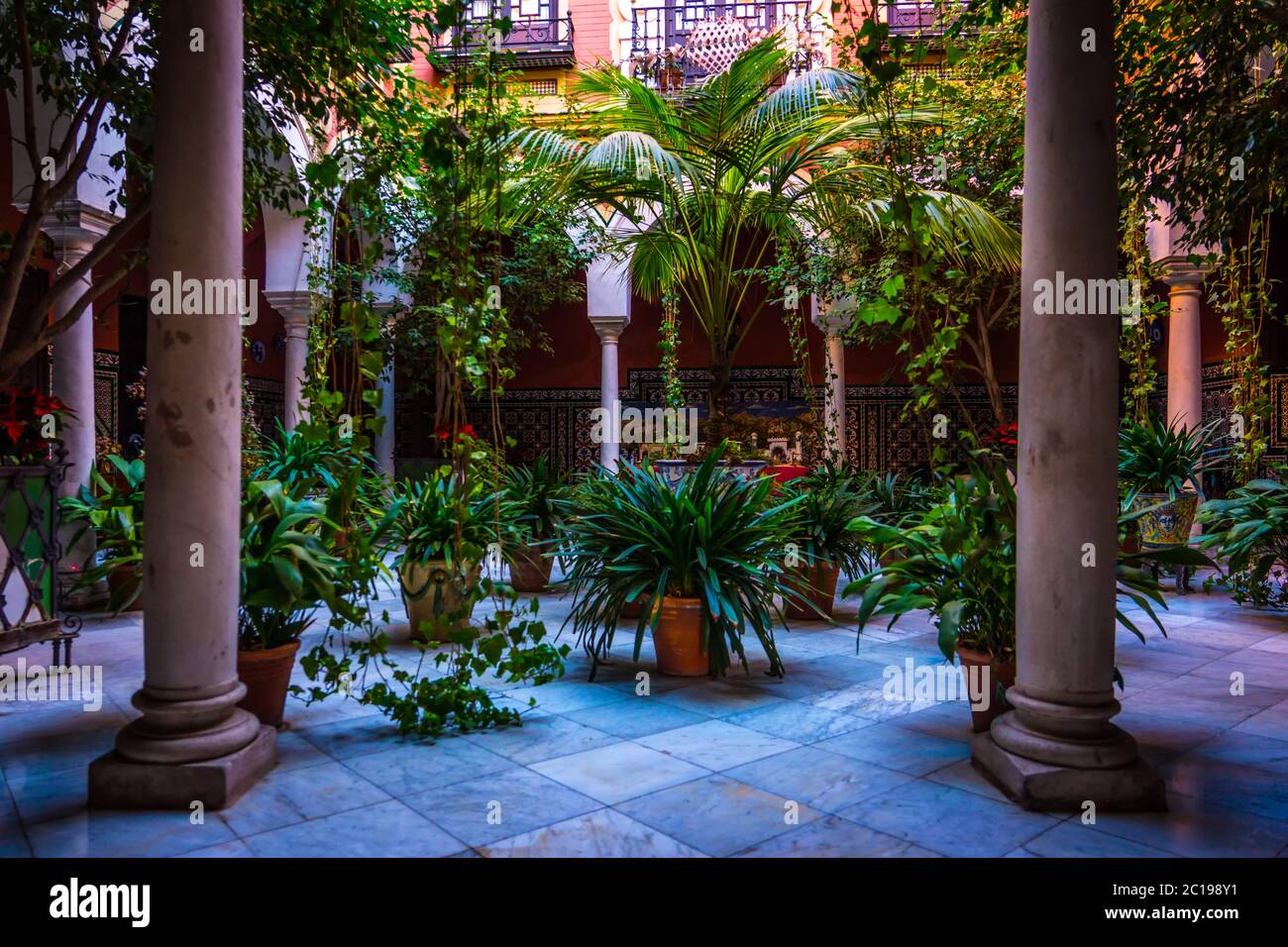 Typical Andalusian patio with fountain and numerous plants geraniums ...