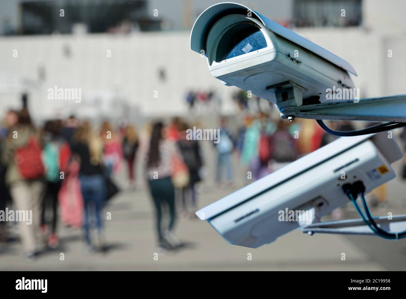 security CCTV camera or surveillance system on the street with tourists ...