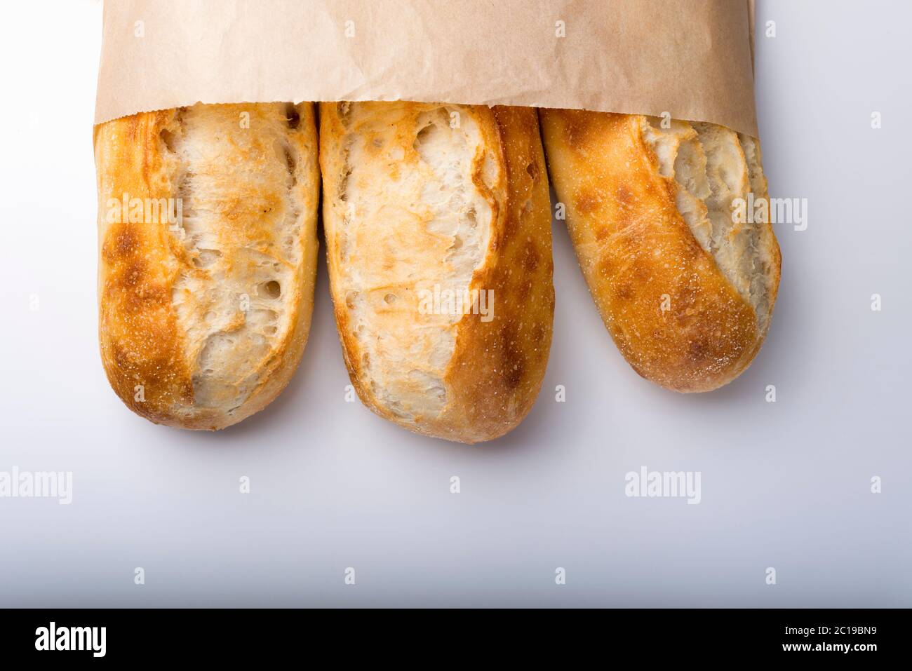 French bread rolls in the paper bag isolated on light background Stock ...