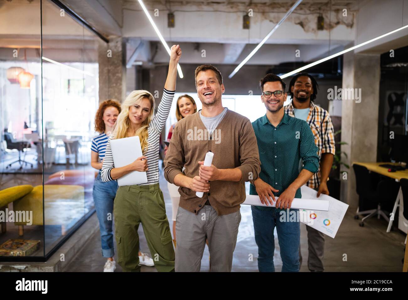 Happy business people celebrating success at company Stock Photo - Alamy