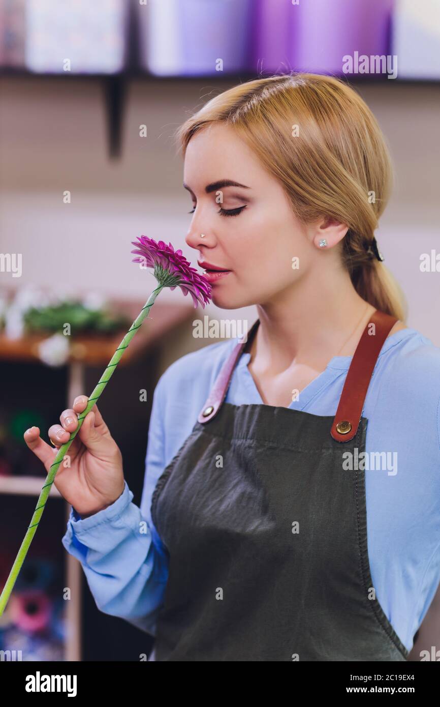 Female sales assistant working as florist and holding bouquet with ...