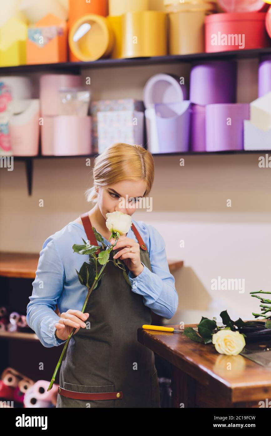 Female sales assistant working as florist and holding bouquet with ...