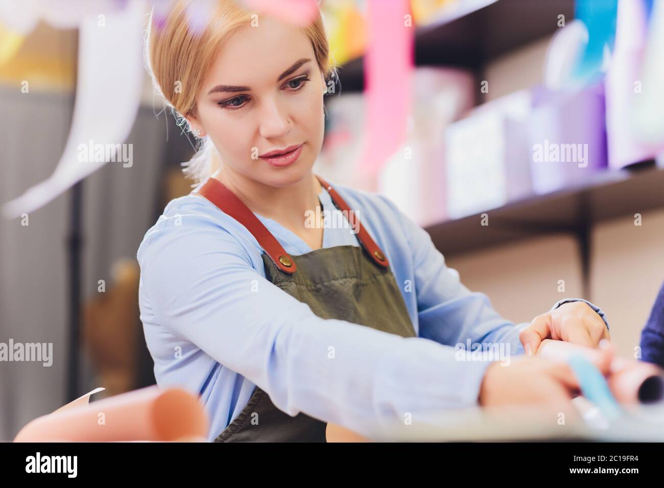 Female sales assistant working as florist and holding bouquet with ...