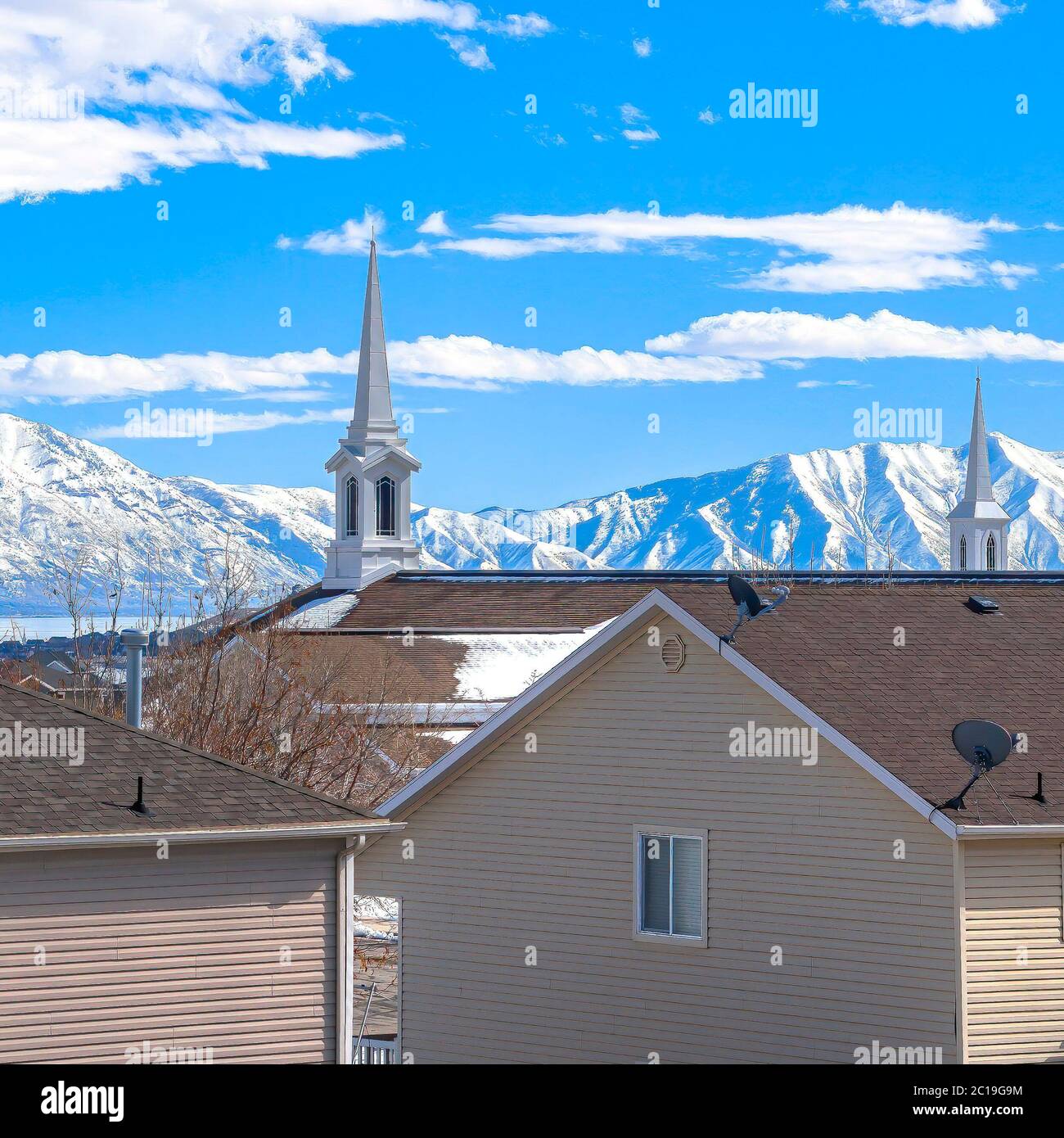 Square crop Homes in the valley against lake snowy mountain and cloudy ...