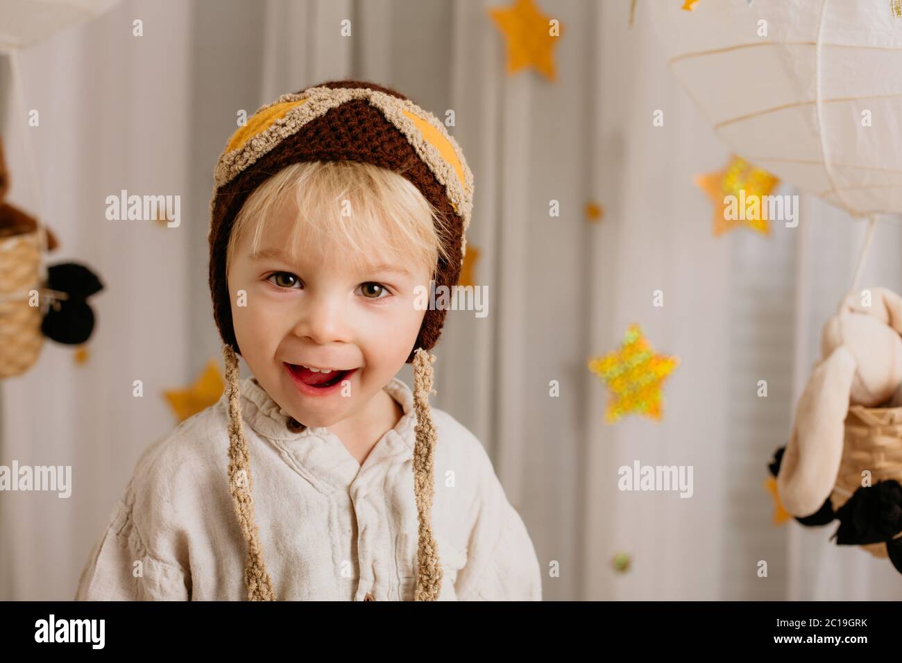Sweet toddler boy, playing with airplane and teddy bear, decorated air ...