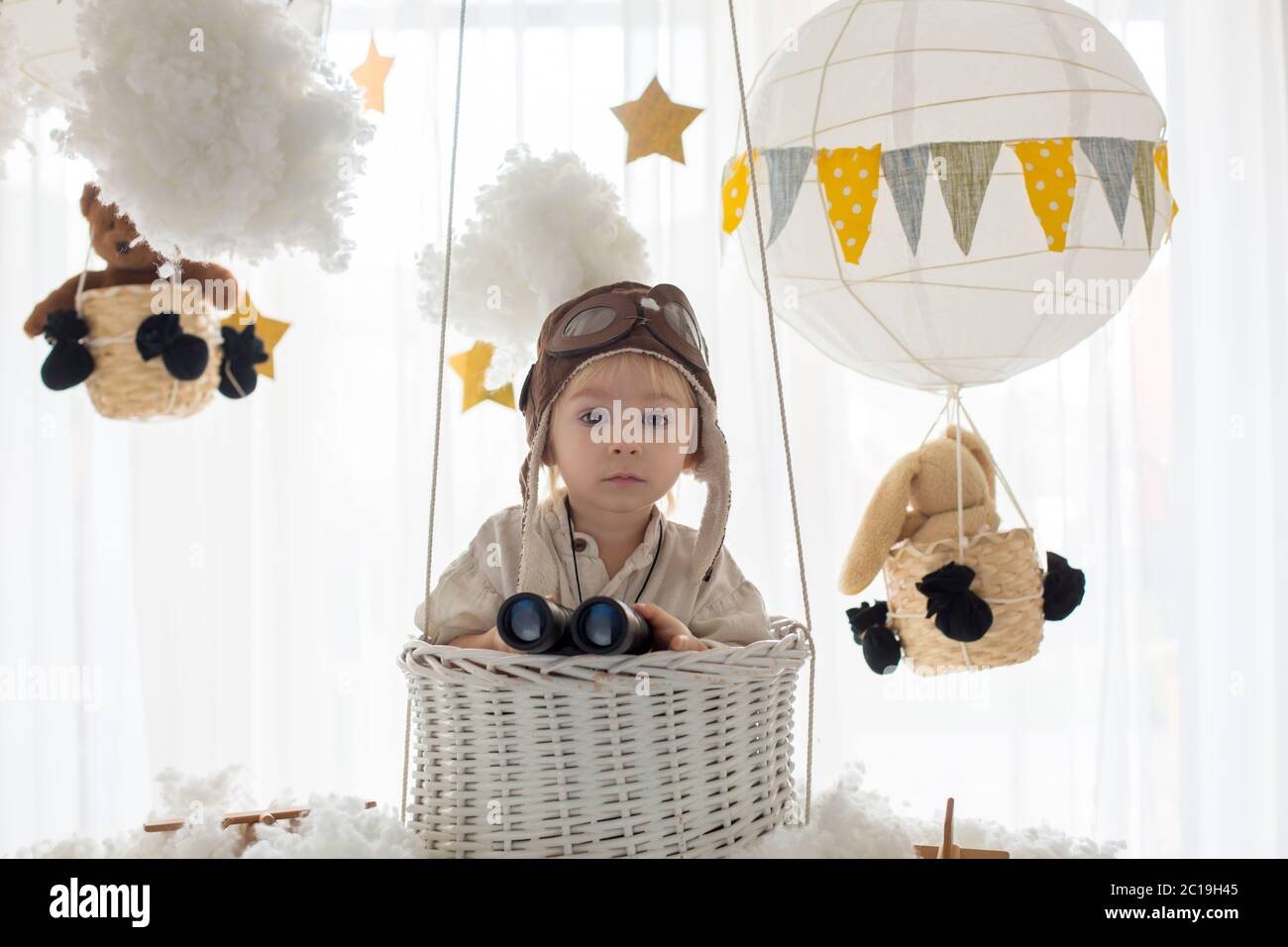 Sweet toddler boy, playing with airplane and teddy bear, decorated air ...