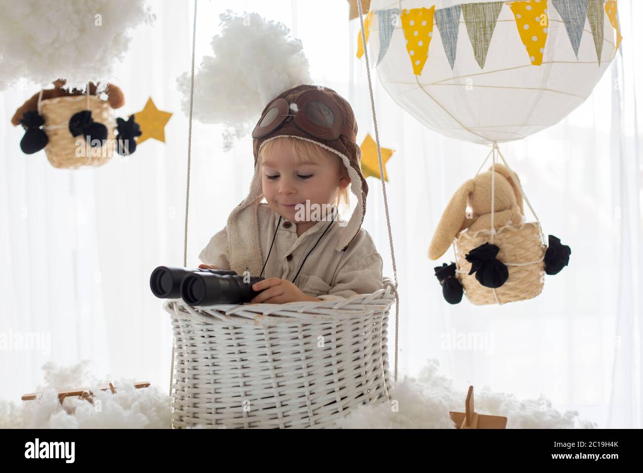 Sweet toddler boy, playing with airplane and teddy bear, decorated air ...
