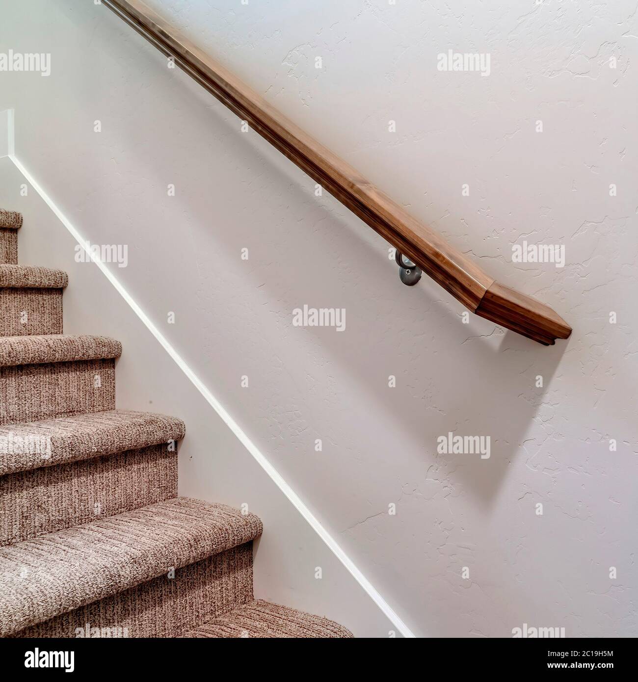 Square Brown wood handrail of staircase and rocker light switch against ...