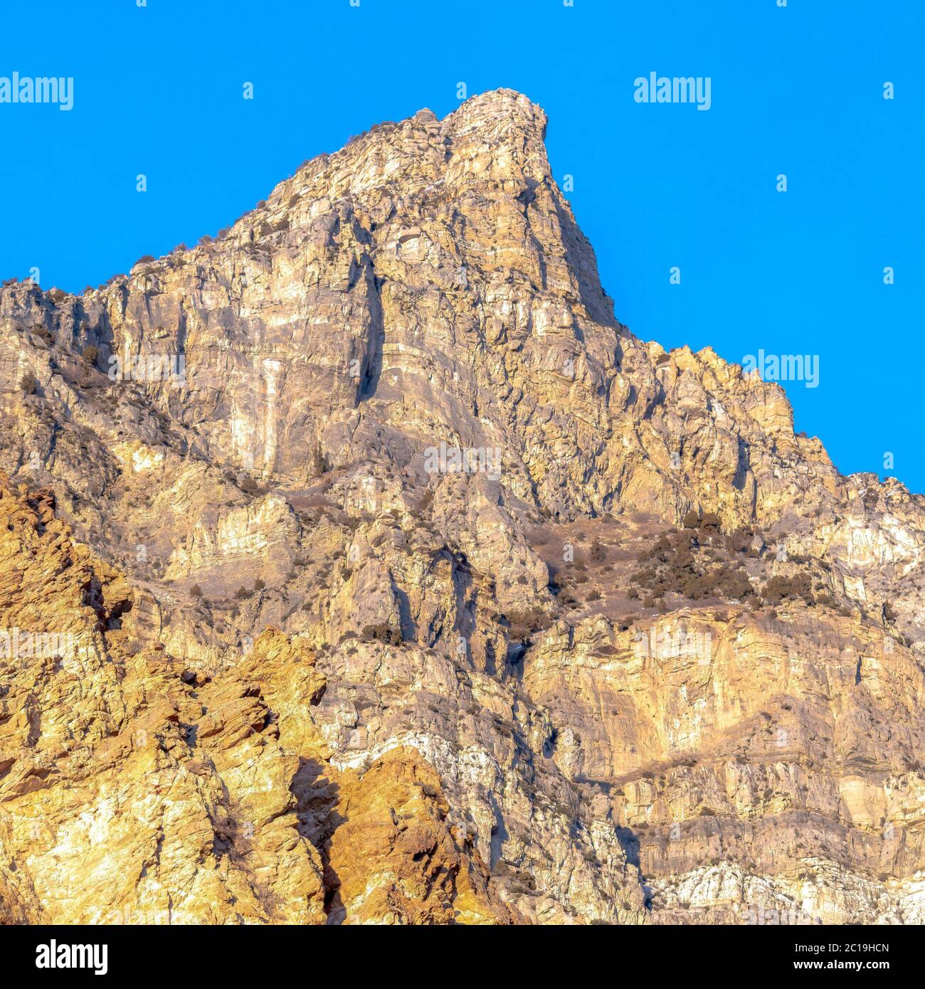 Square Precipitous slope of a rocky mountain gainst clear blue sky in ...