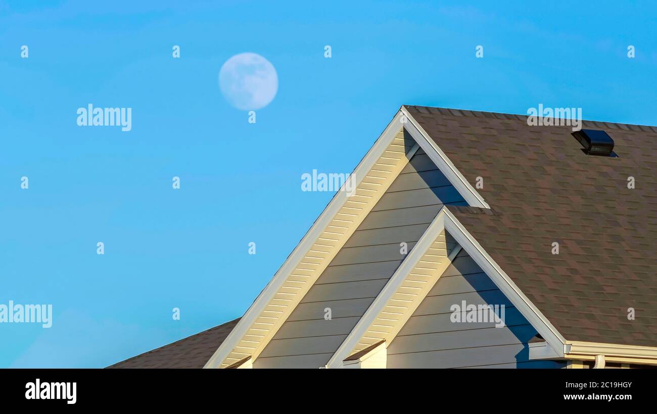 Panorama Facade of sunlit home in the suburb with vast blue sky ...