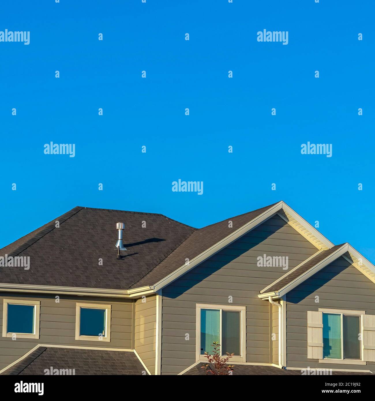 Square Home exterior with view of the upper storey agaist clear blue ...