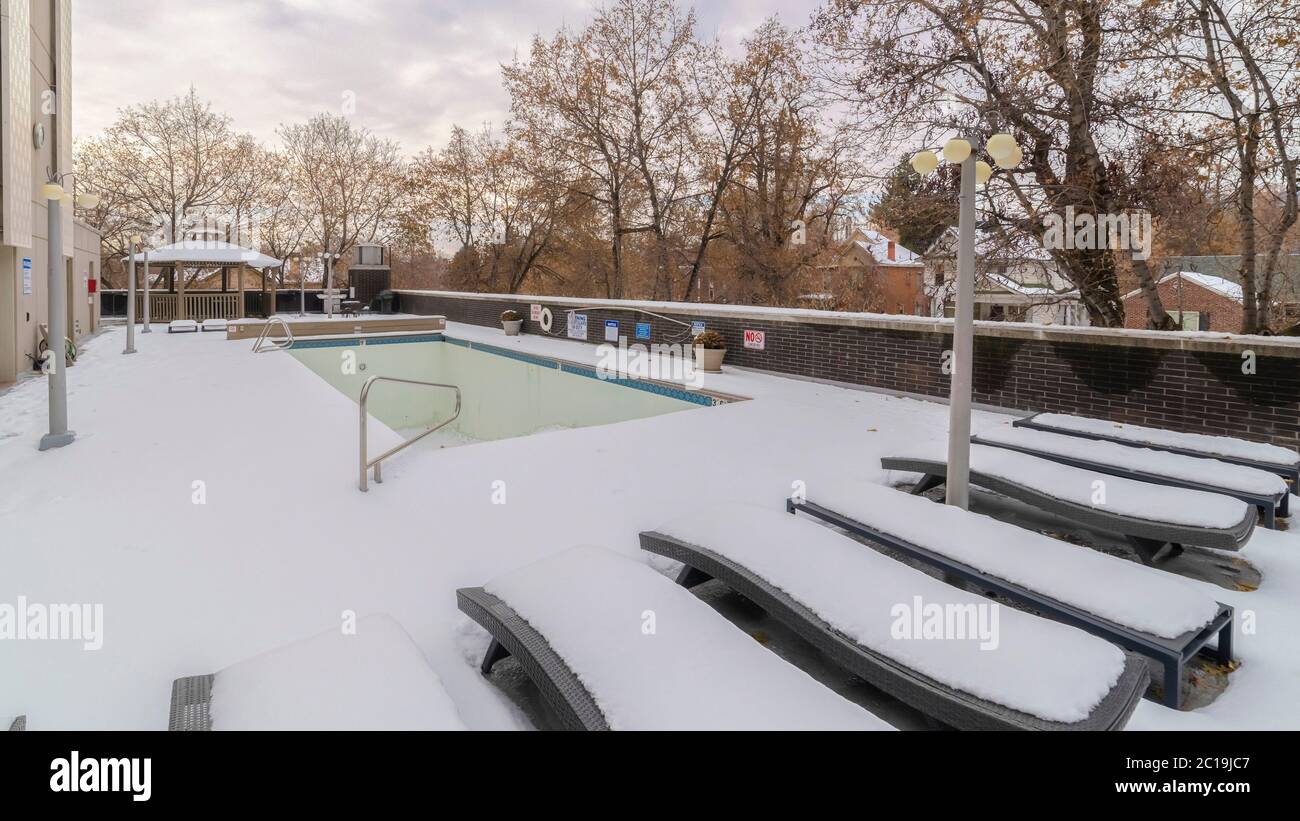 Panorama frame Snow covered recliner beds around a pool Stock Photo - Alamy